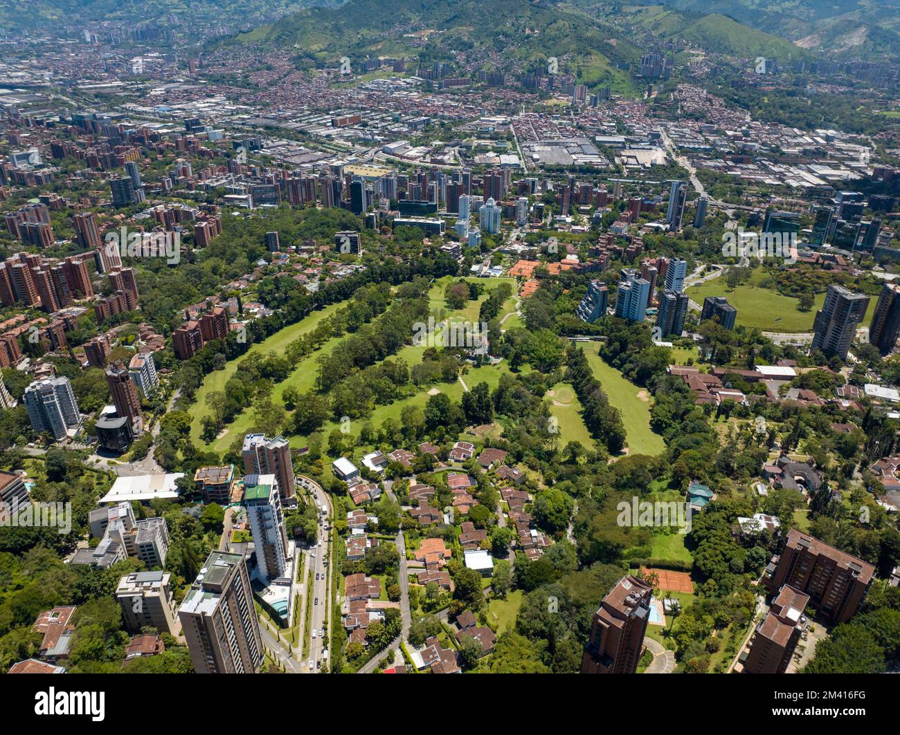 An aerial view of Medellin city with high buildings and green nature on ...