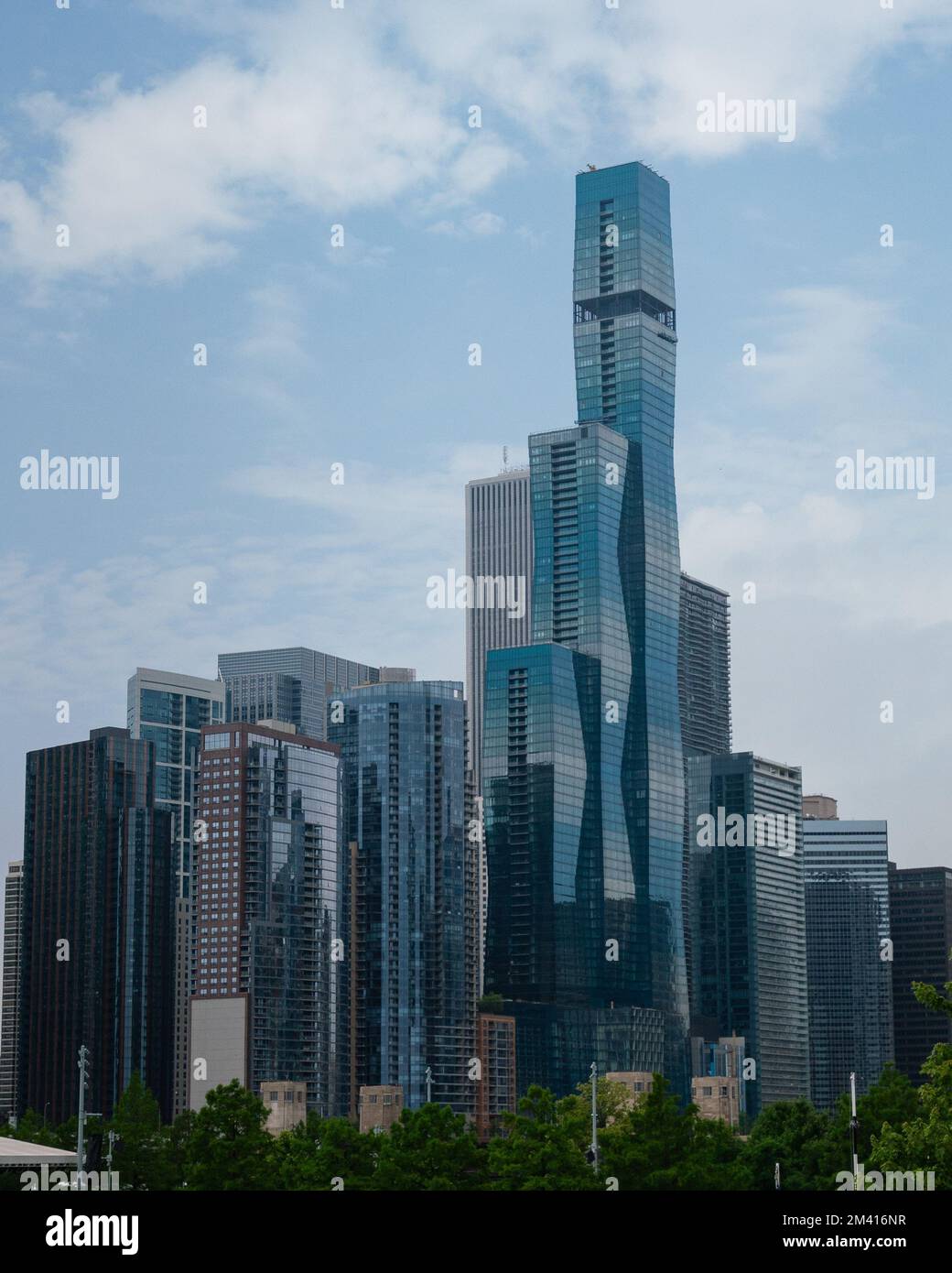 A vertical shot of high blue skyscrapers in Chicago in cloudy sky ...