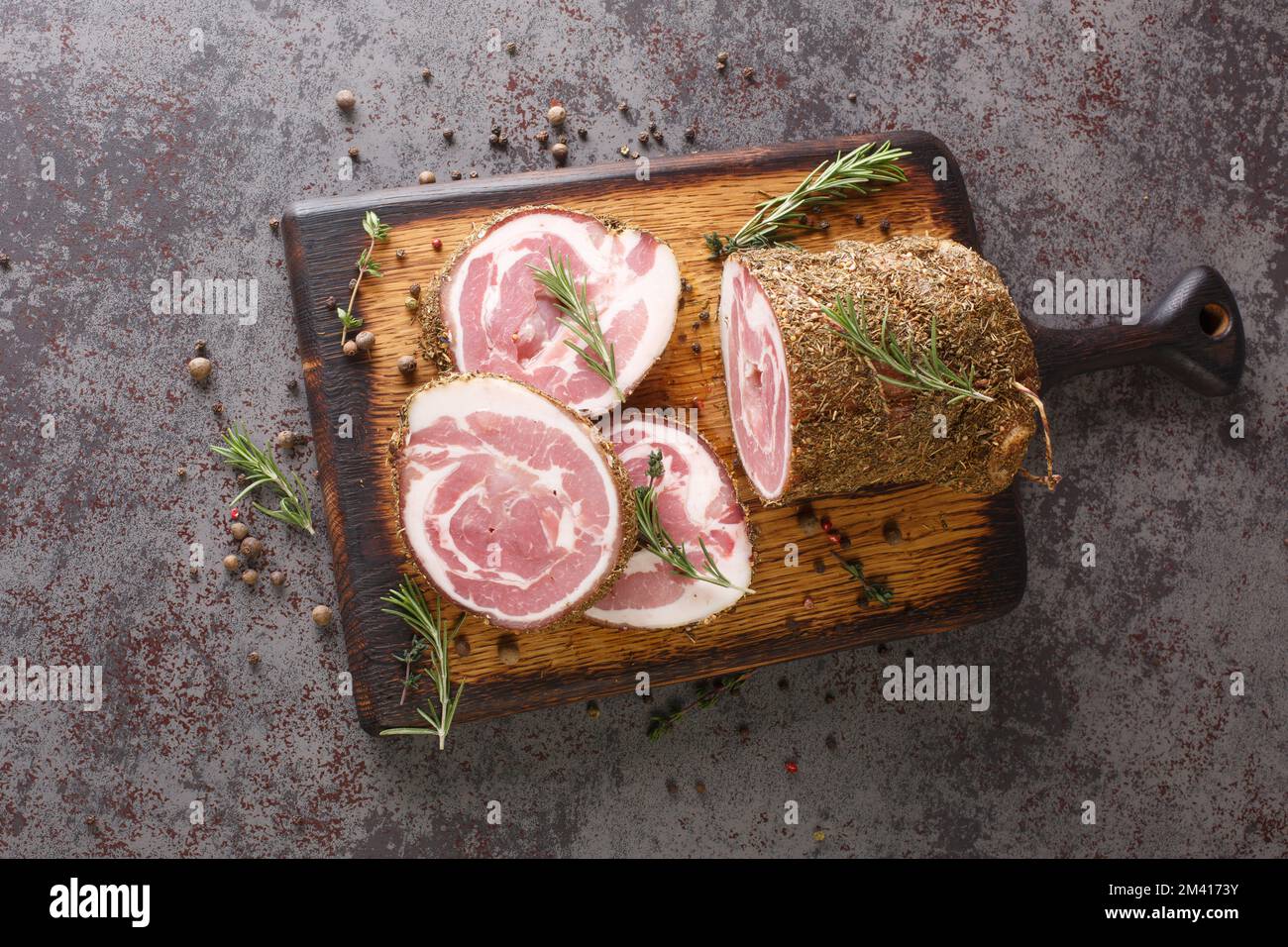 Italian traditional bacon pancetta on a cutting board closeup on the ...