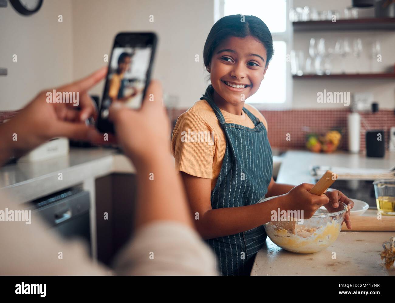 Baking, girl and phone picture of a child cooking in home kitchen with ...