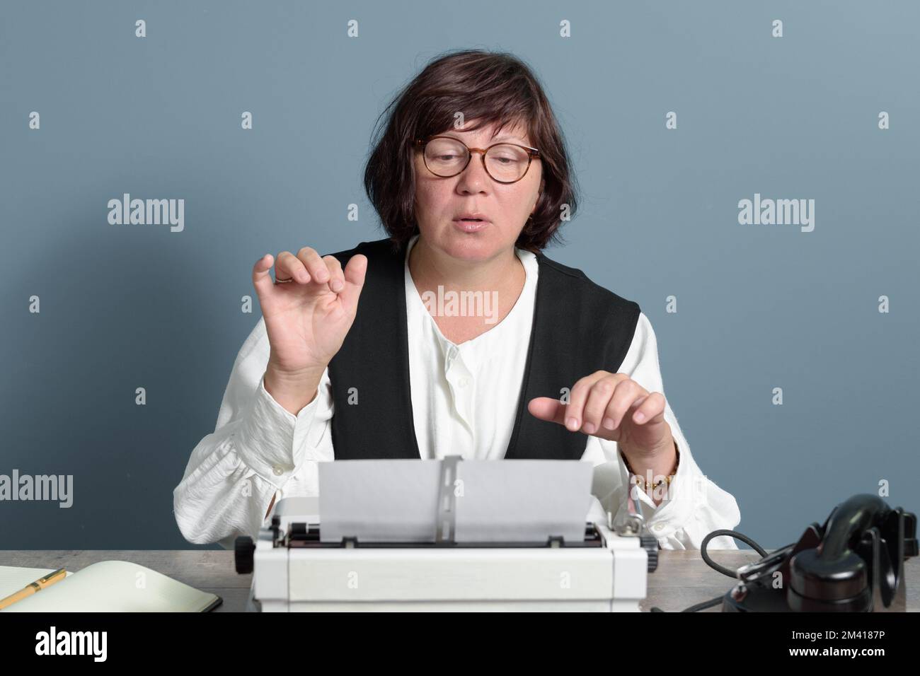 Retro office. Experienced secretary woman with glasses typing text on ...