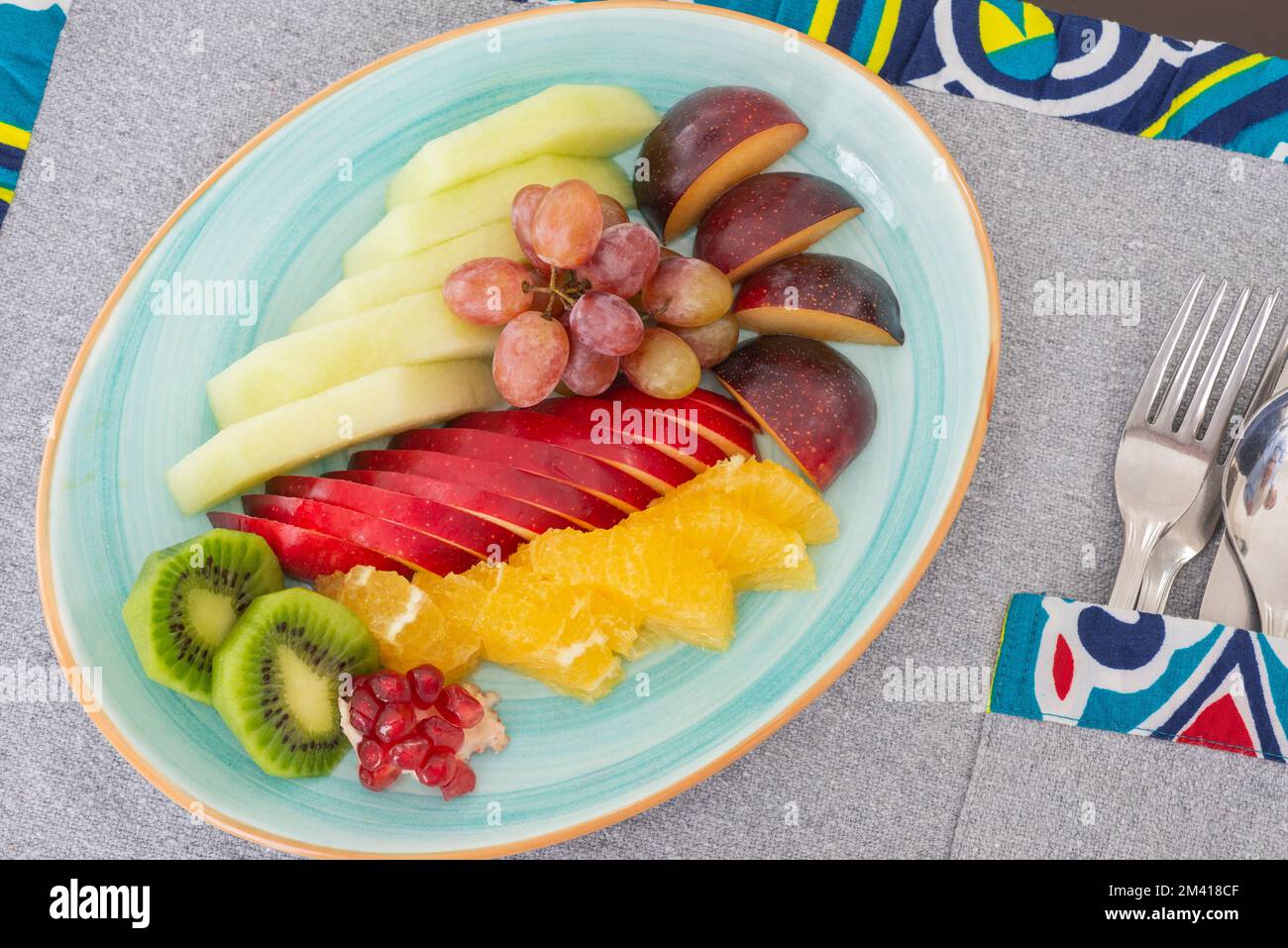 Selection of fresh fruit platter on a plate at restaurant table setting ...