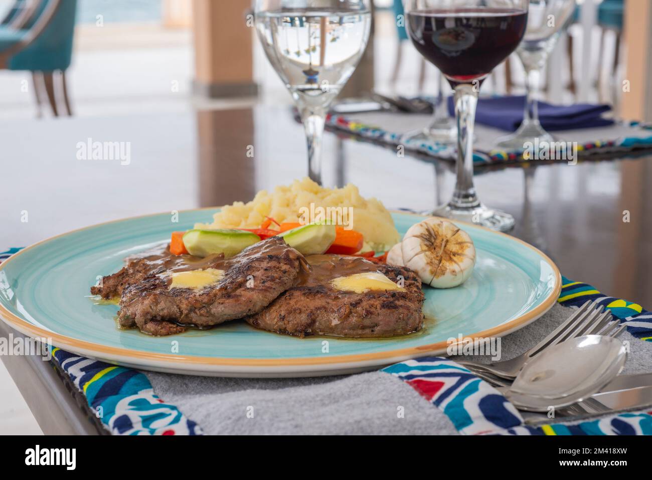 Beef steak a la carte meal with pepper sauce on blue plate with ...