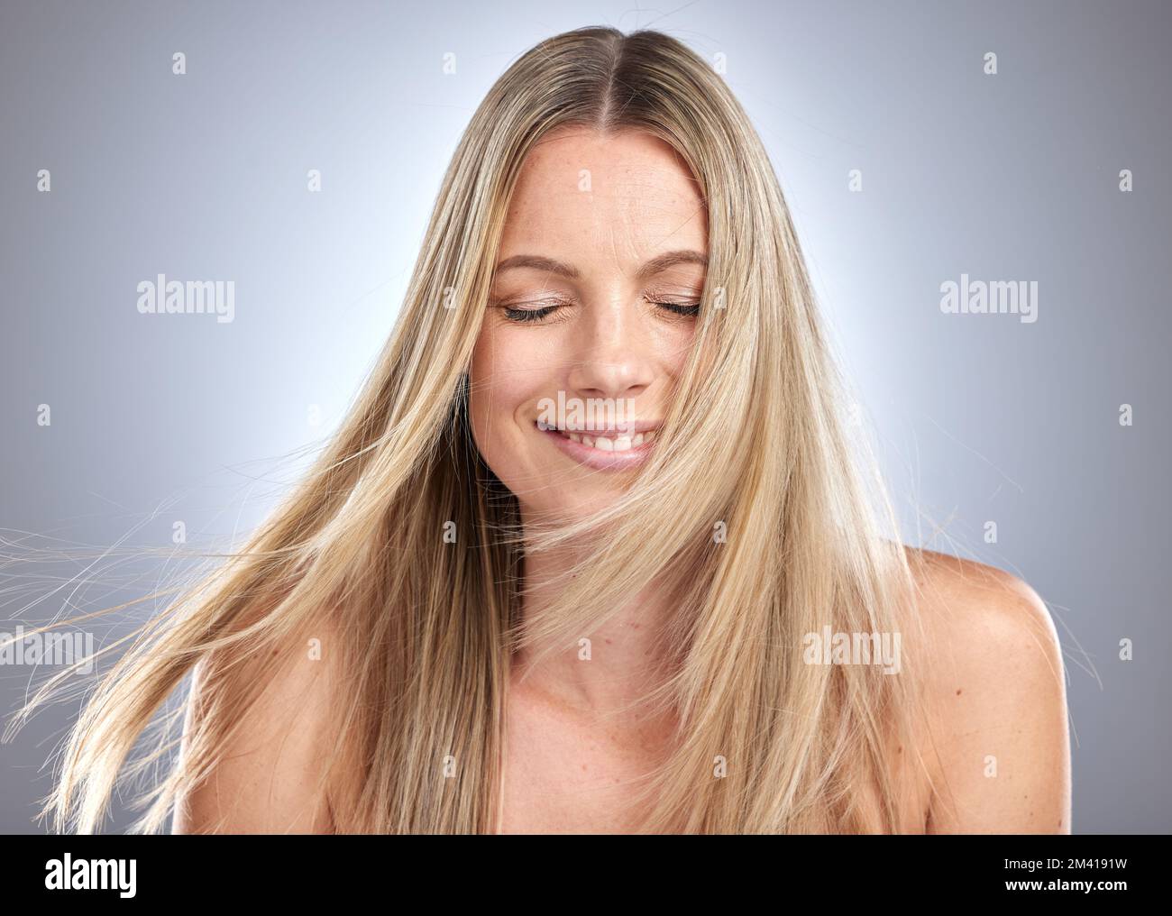 Hair, beauty and face with a model woman in studio on a gray background ...