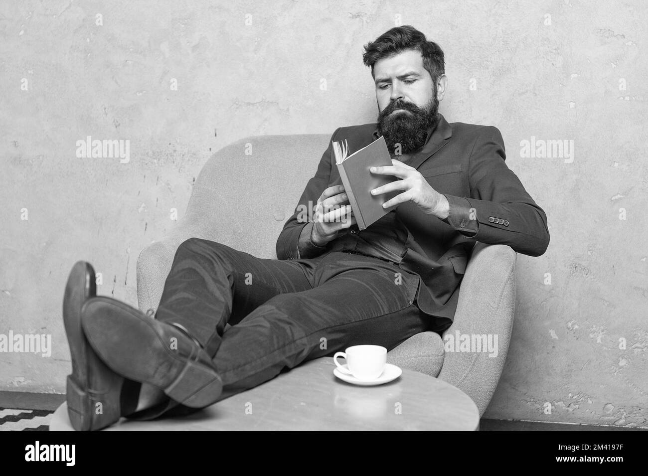 Bearded man ceo read book relaxing in armchair during rest break ...