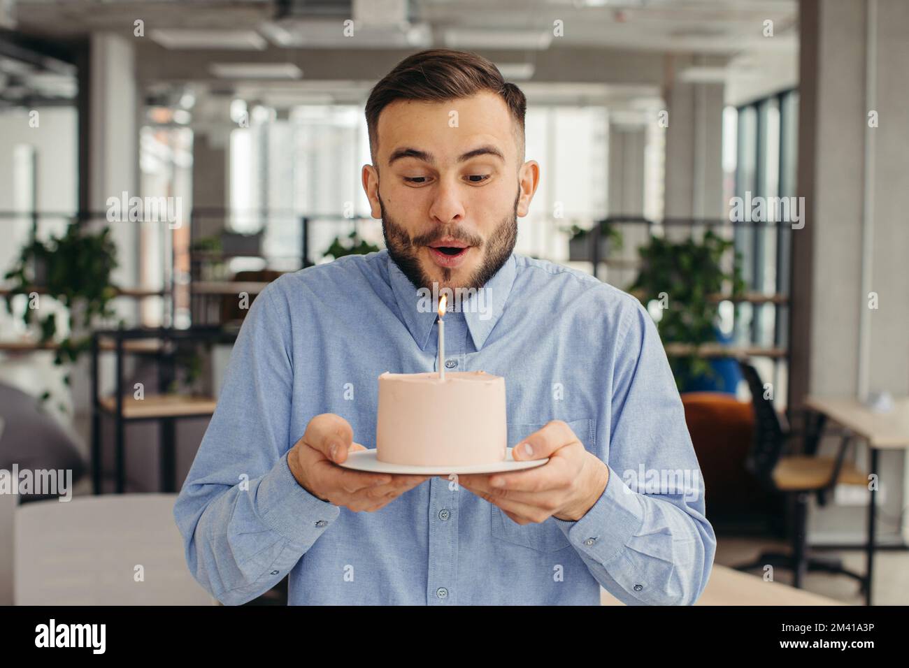 Excited man celebrating birthday in office, looking happy, holding cake ...