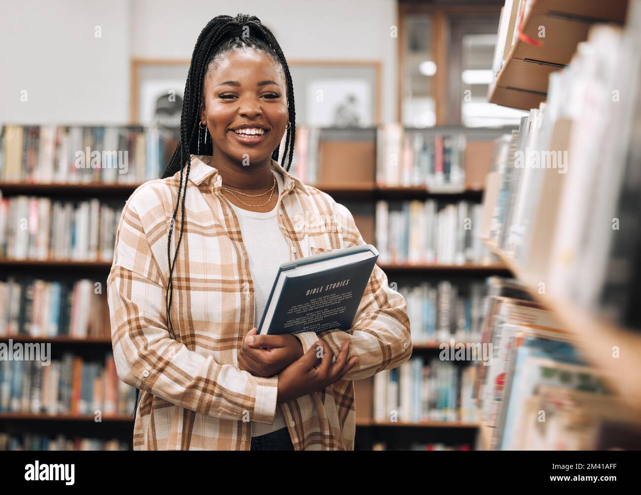 Portrait, black woman and library with book, knowledge and relax with ...