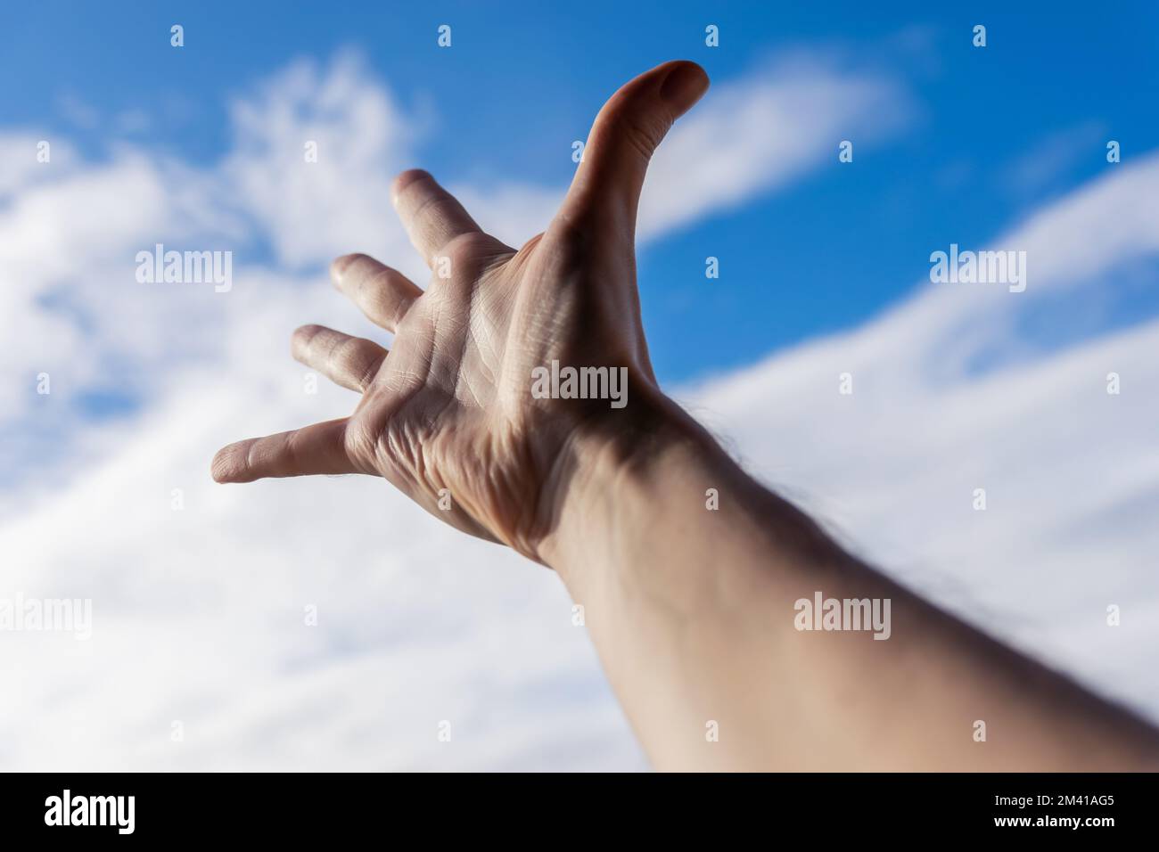 Hand of a man reaching to towards sky Stock Photo - Alamy