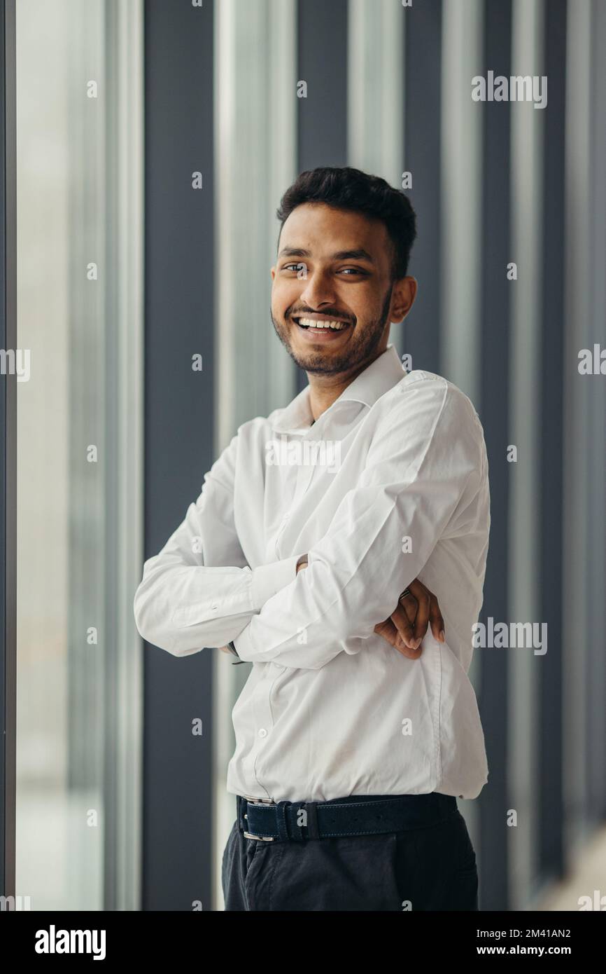 Young Hindu businessman posing near the window in the office Stock ...