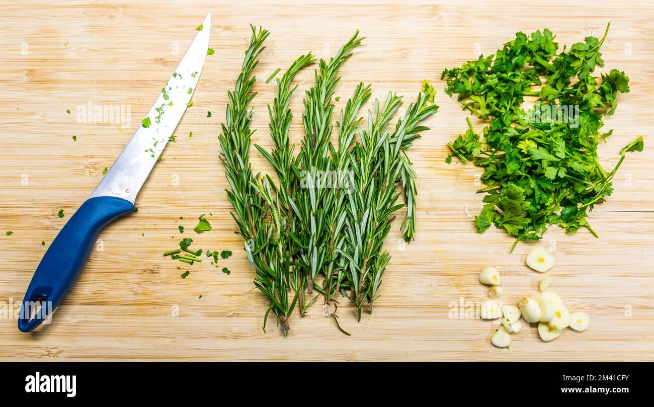 Thyme and parley placed on the wooden desk with knife. Fresh and ...