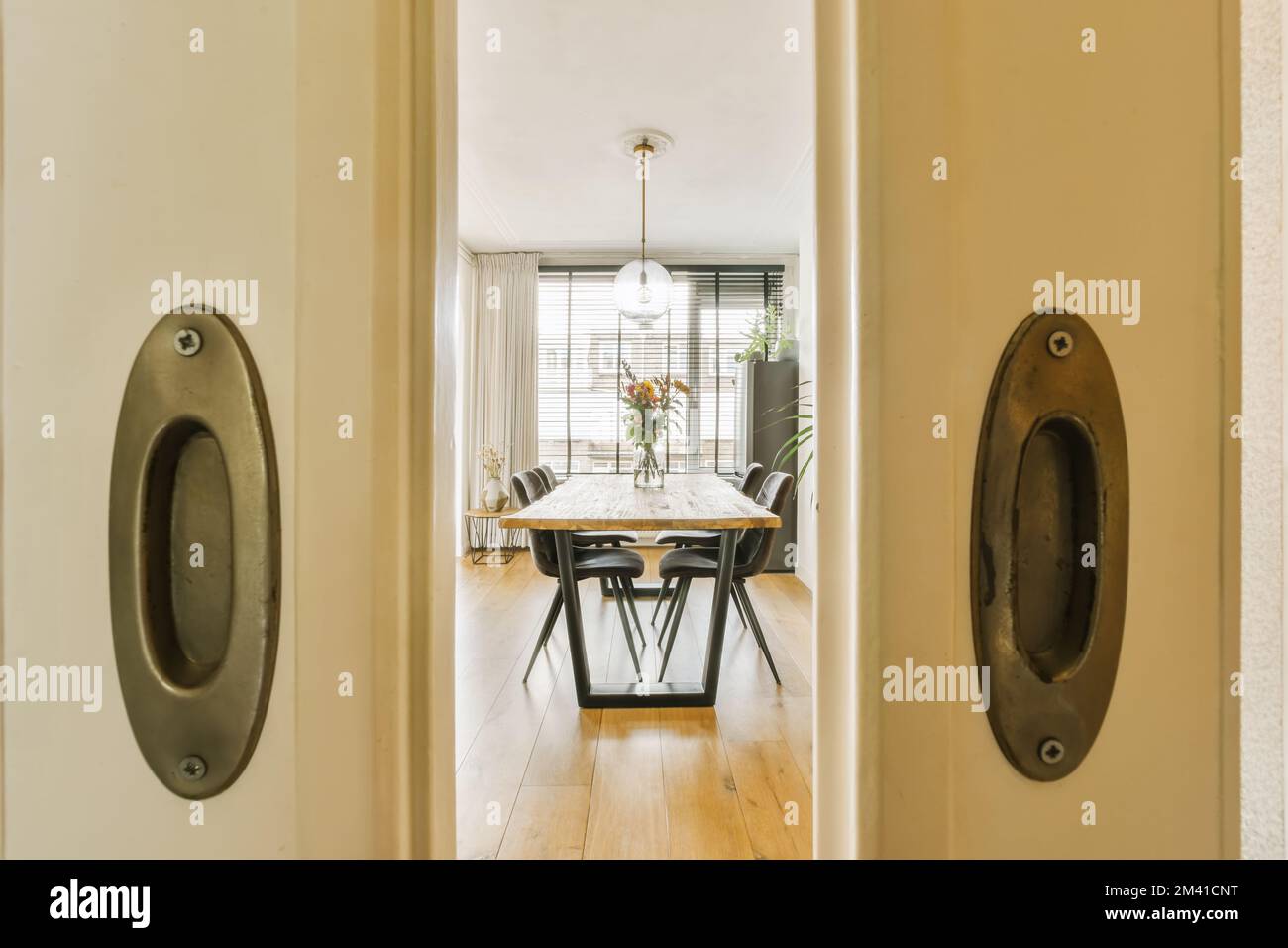 an open door leading to a dining room with two chairs and a table in ...