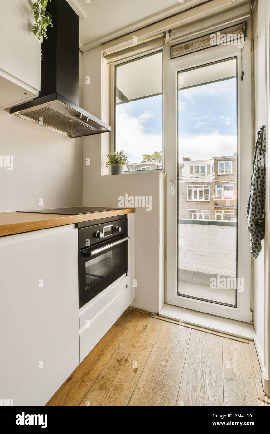 a kitchen area with wood flooring and white walls, including an open ...