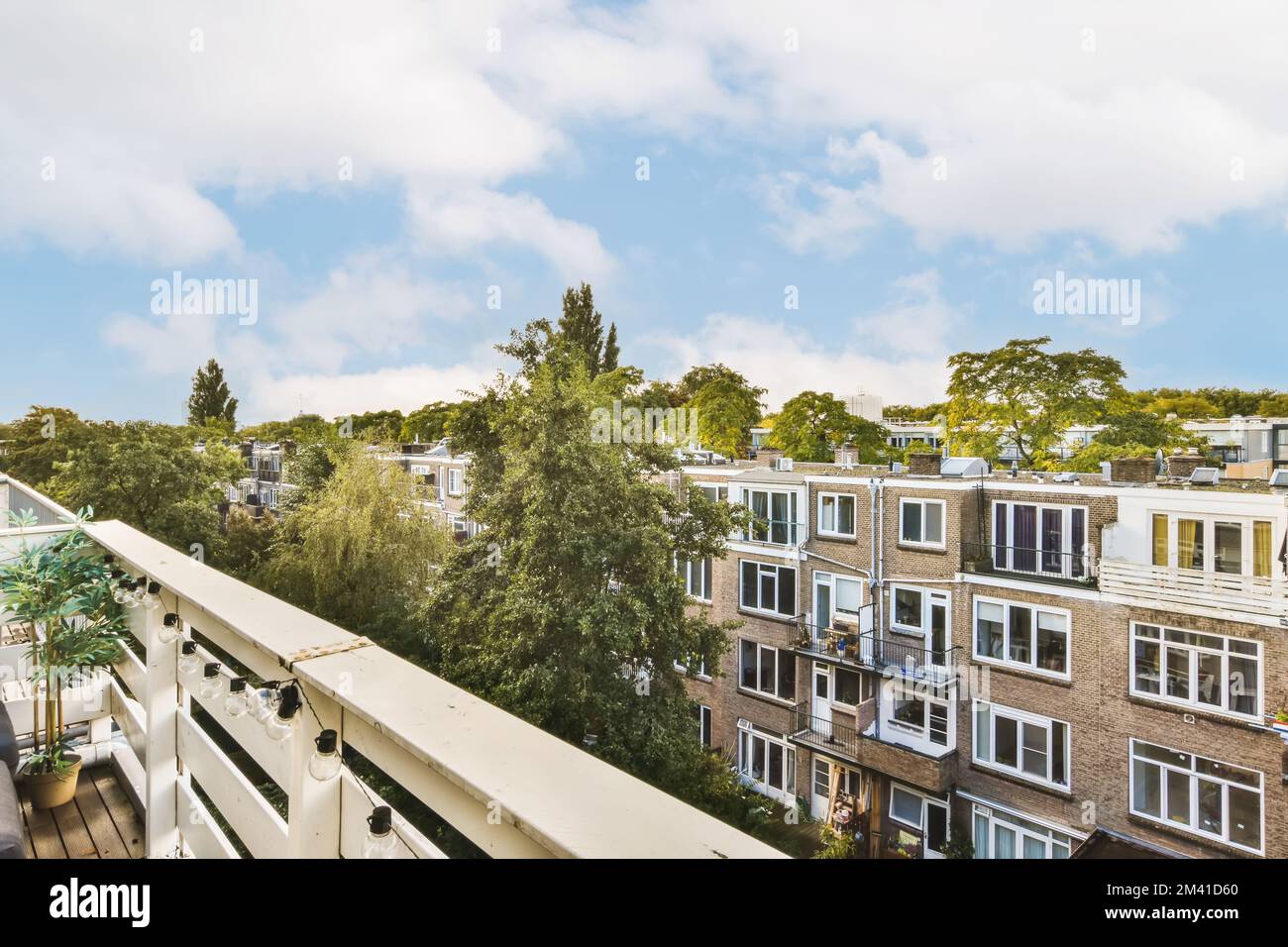 a balcony with trees and buildings in the background, taken from an ...