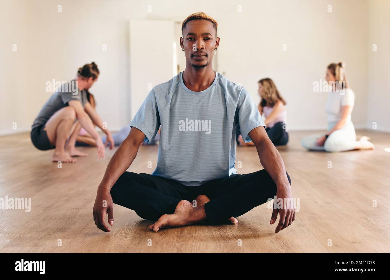 Portrait of a male yogi looking at the camera while sitting in lotus ...