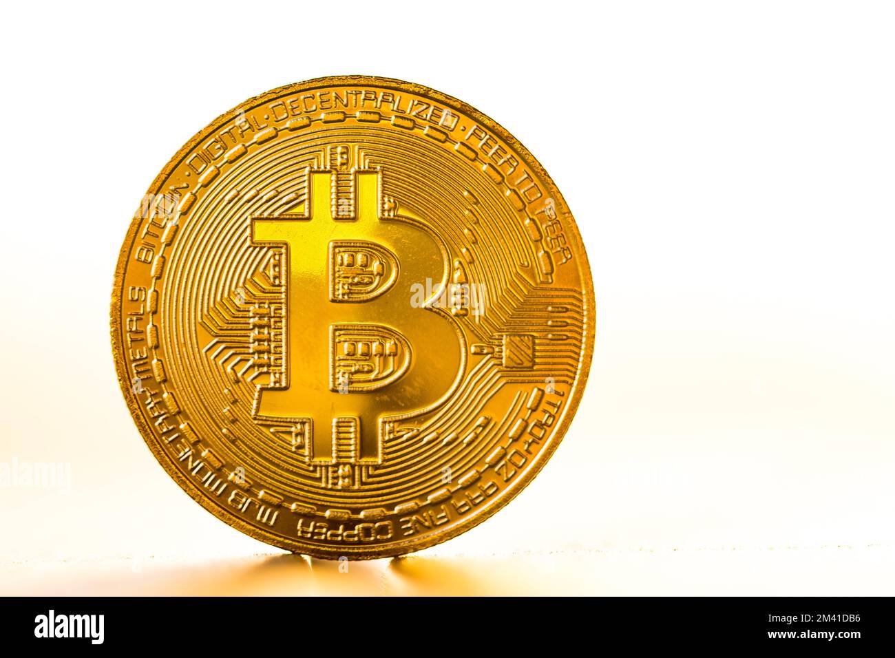 Gold bitcoin coin placed on white background in the light of sunset ...