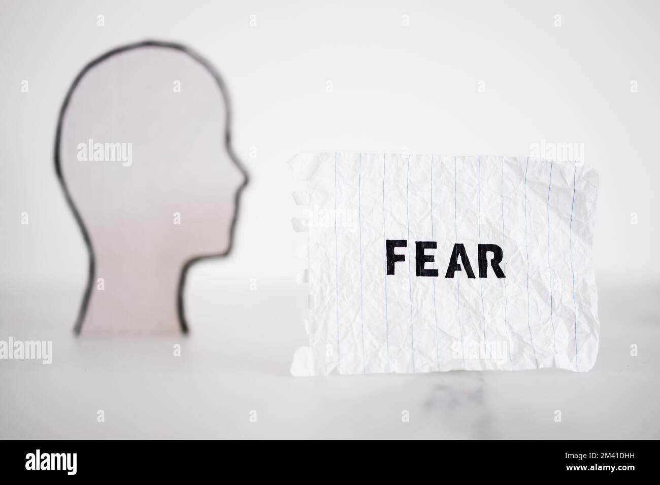 cardboard head next to Fear text on white marble background, psychology ...