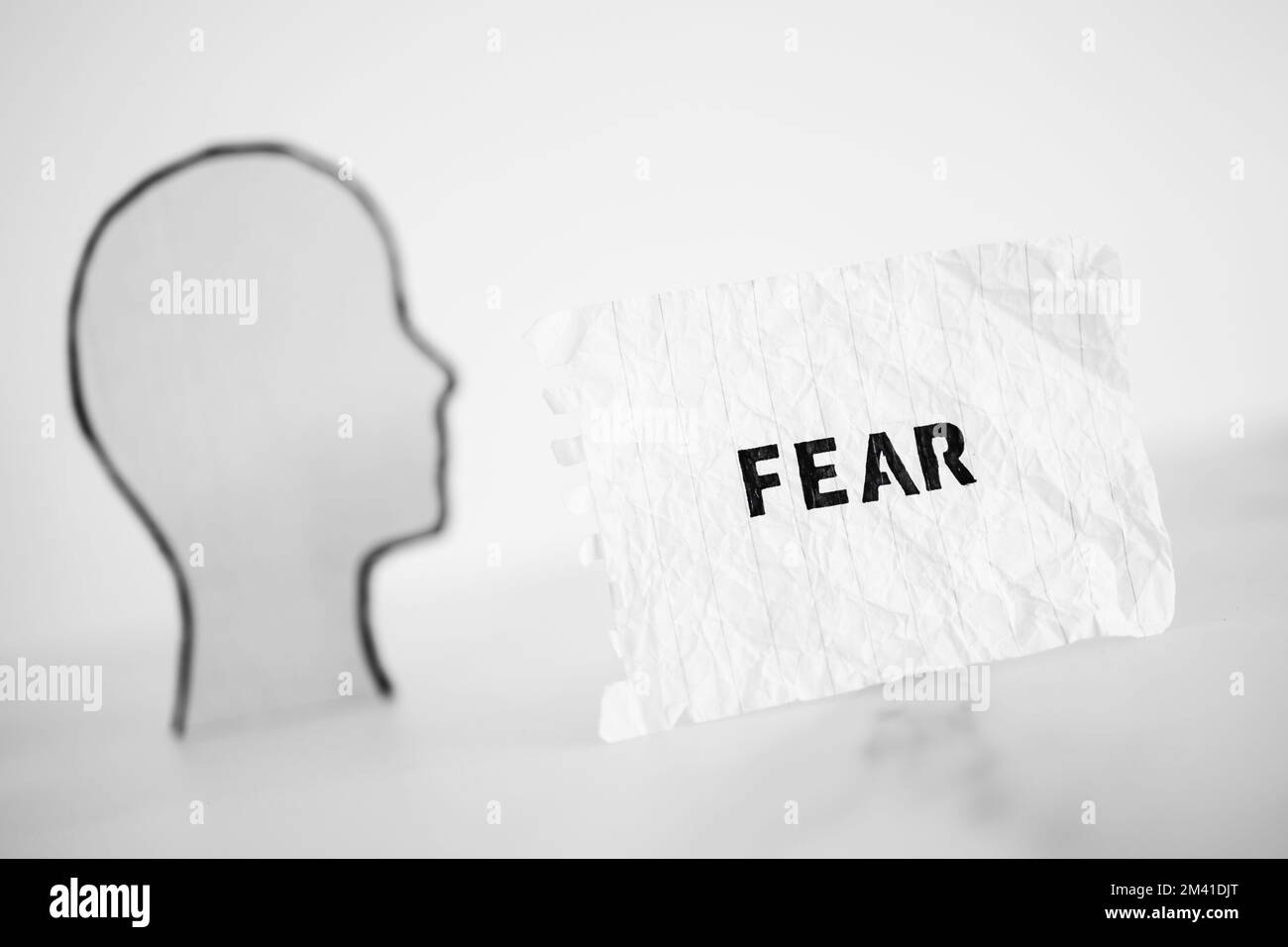 cardboard head next to Fear text on white marble background, psychology ...