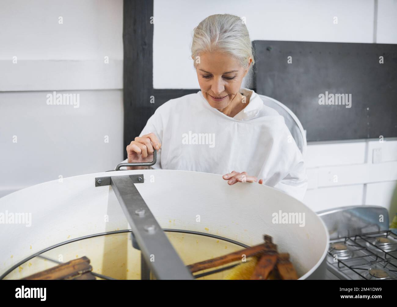 Beekeeper woman, factory and honey production with machine, focus and ...