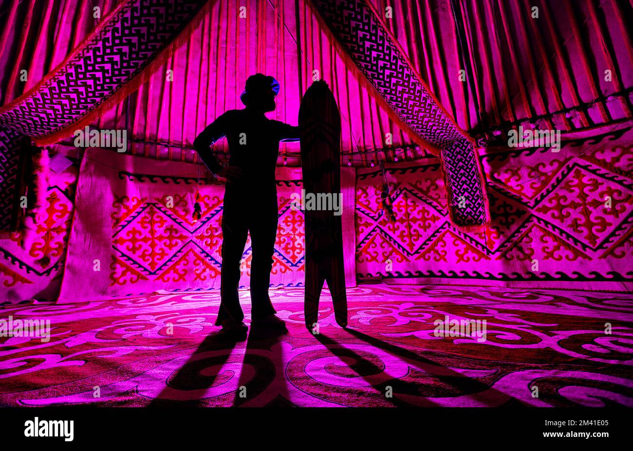 Silhouette of Man holding with split snowboard inside Yurt nomadic ...