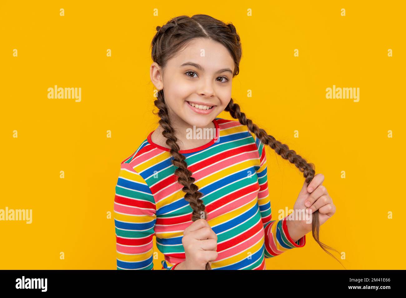 photo of cheerful teen girl having braids. childhood studio shot of ...