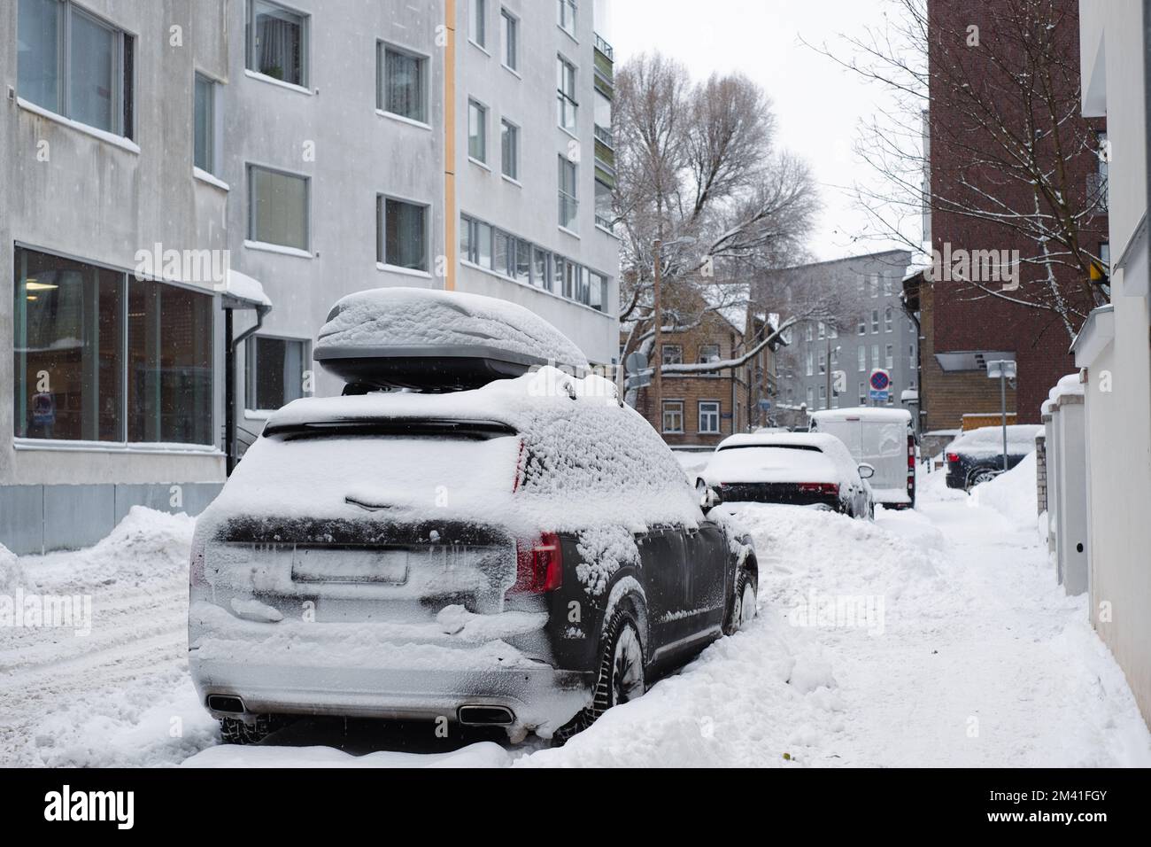 Difficult weather conditions. Street and sidewalk under snow piles ...