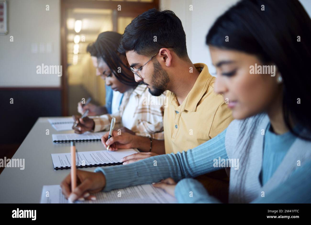 Education, university and students writing exam in a classroom, vision ...