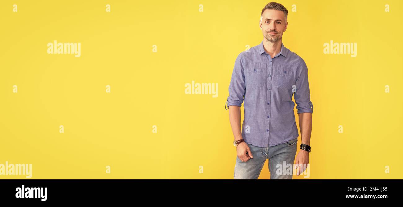 smiling adult man with hand watch on yellow background, fashion ...