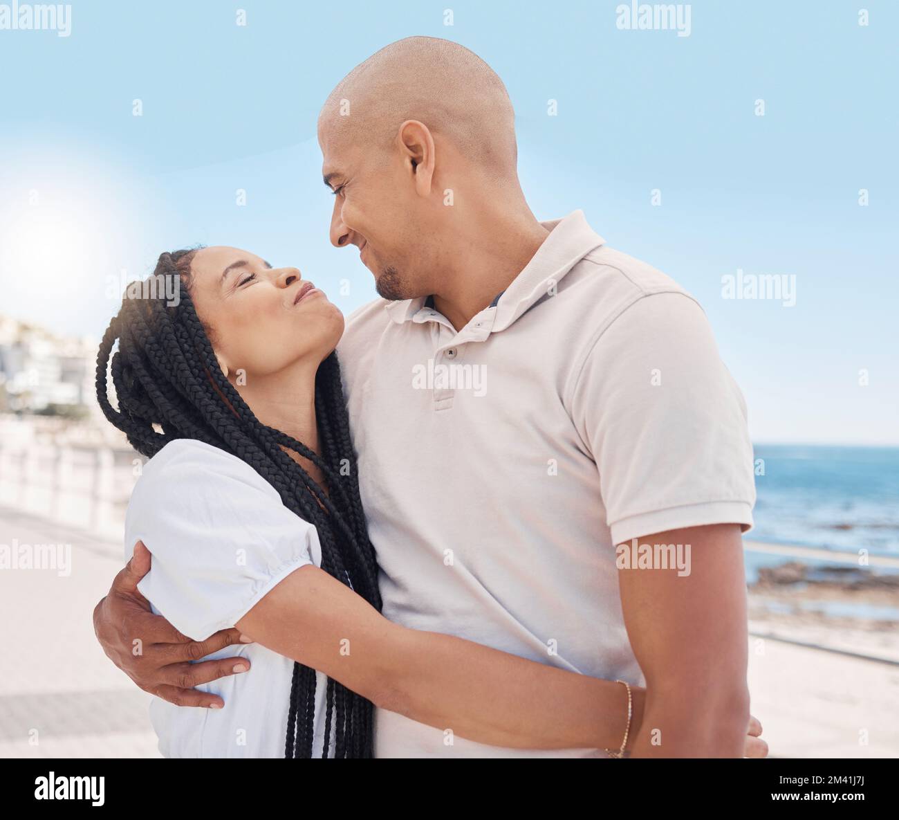Love, hug and happy couple at beach promenade for summer vacation ...