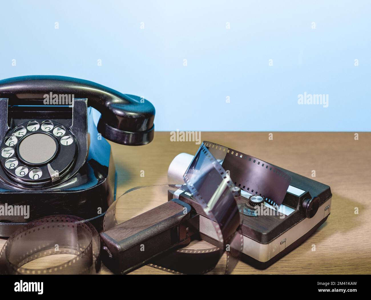 Old movie camera, film and old phone on the table. retro scene. light ...