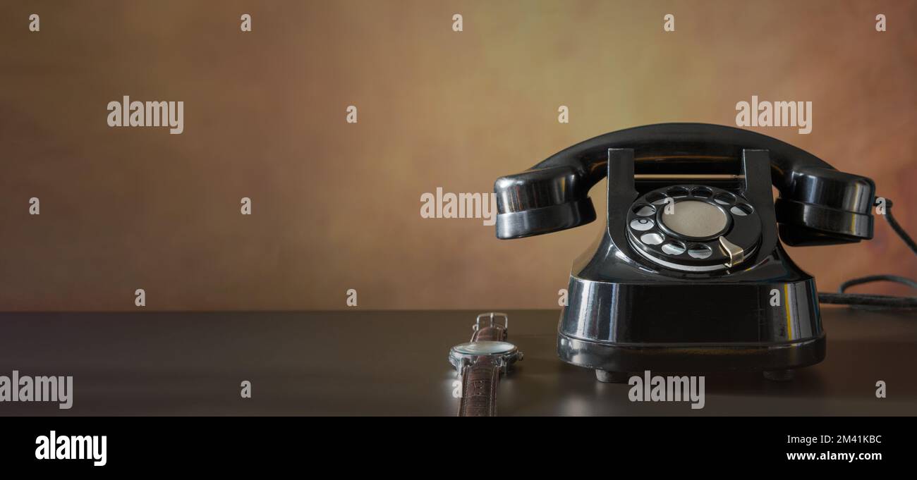 Old telephone set and wrist watch on a wooden table, banner. Vintage ...