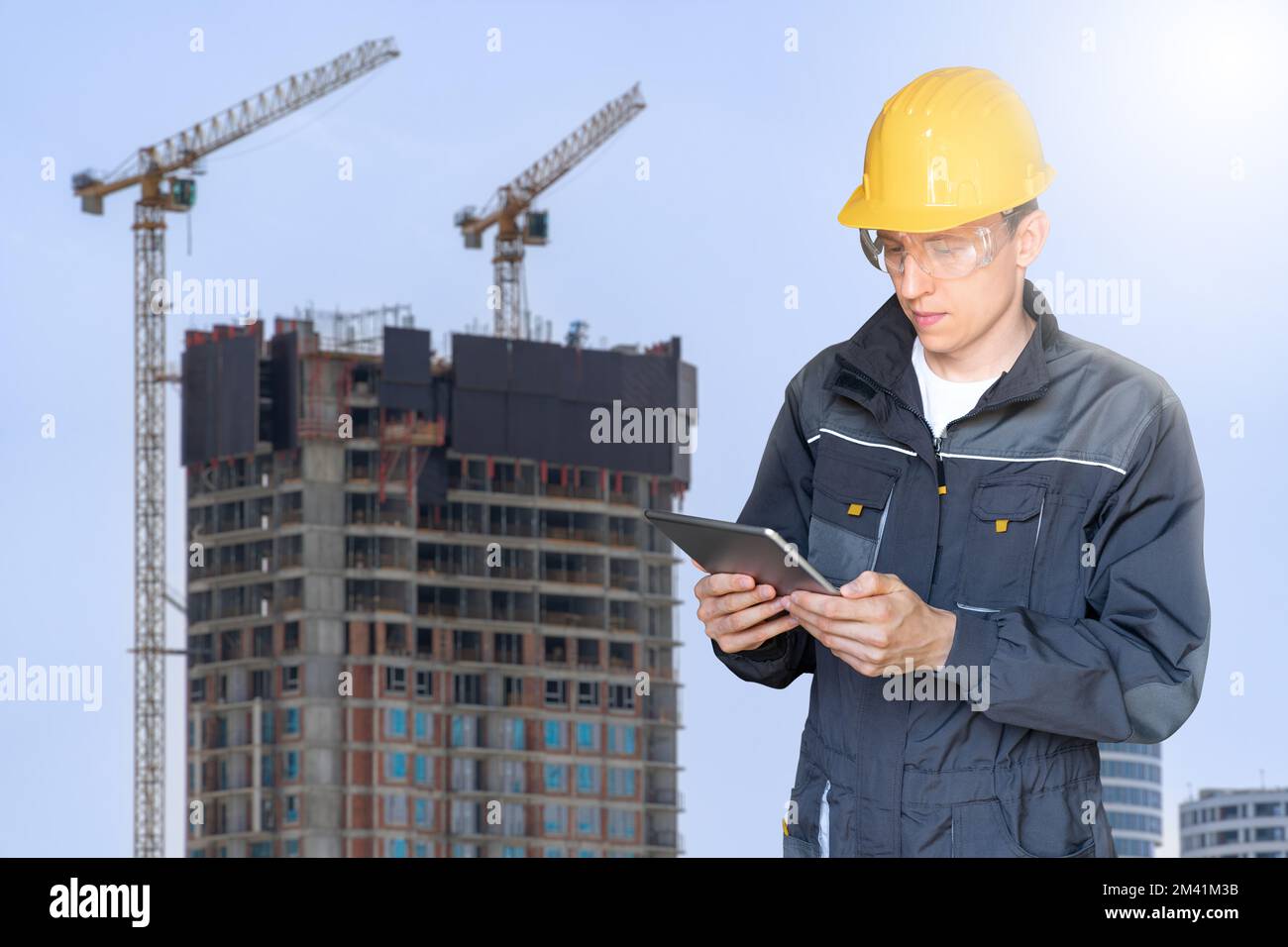 Engineer with a digital tablet on the background of a building under ...