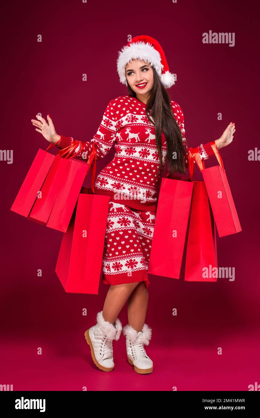 Attractive woman is holding many packages of bought presents with both ...