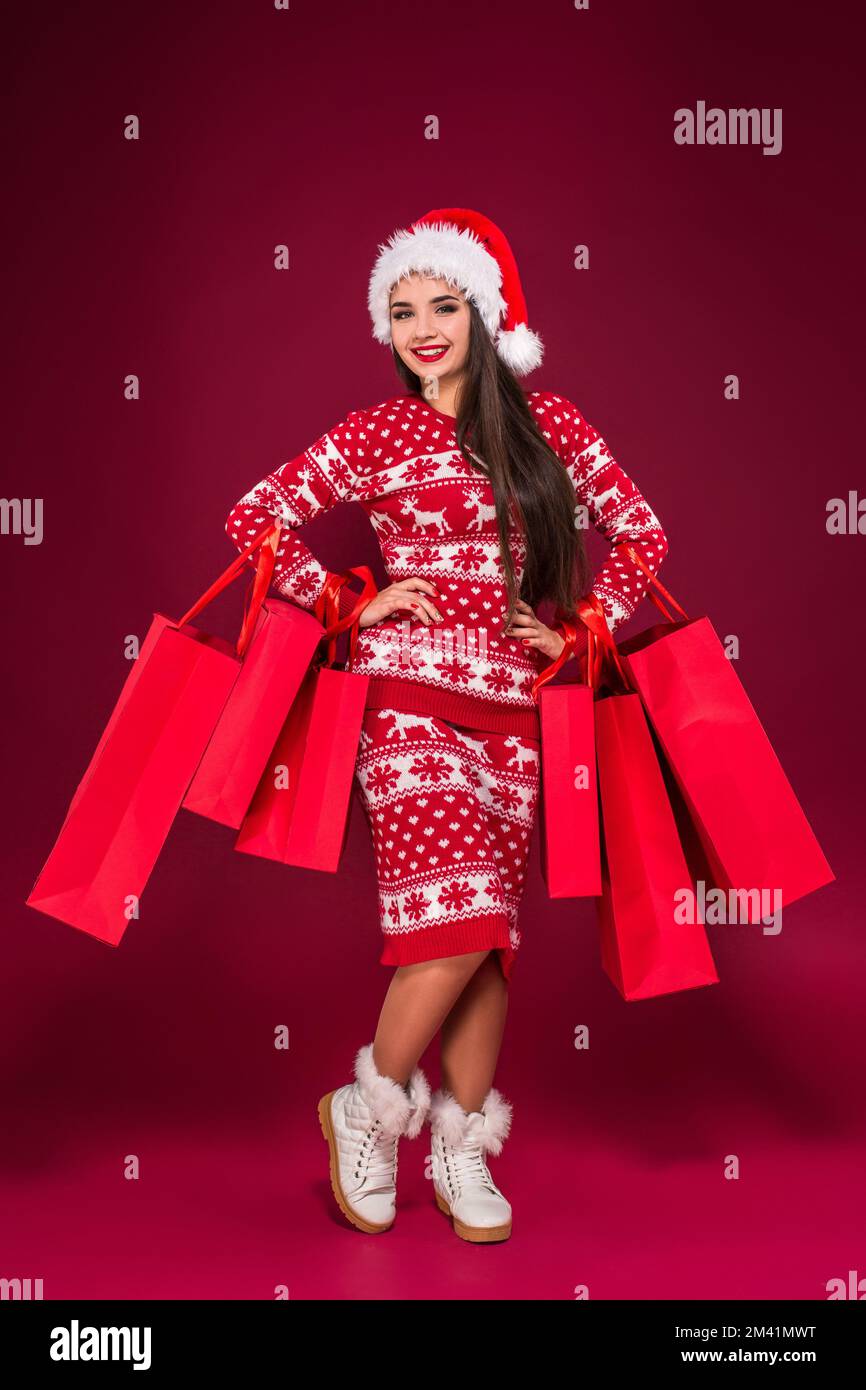 Attractive woman is holding many packages of bought presents with both ...