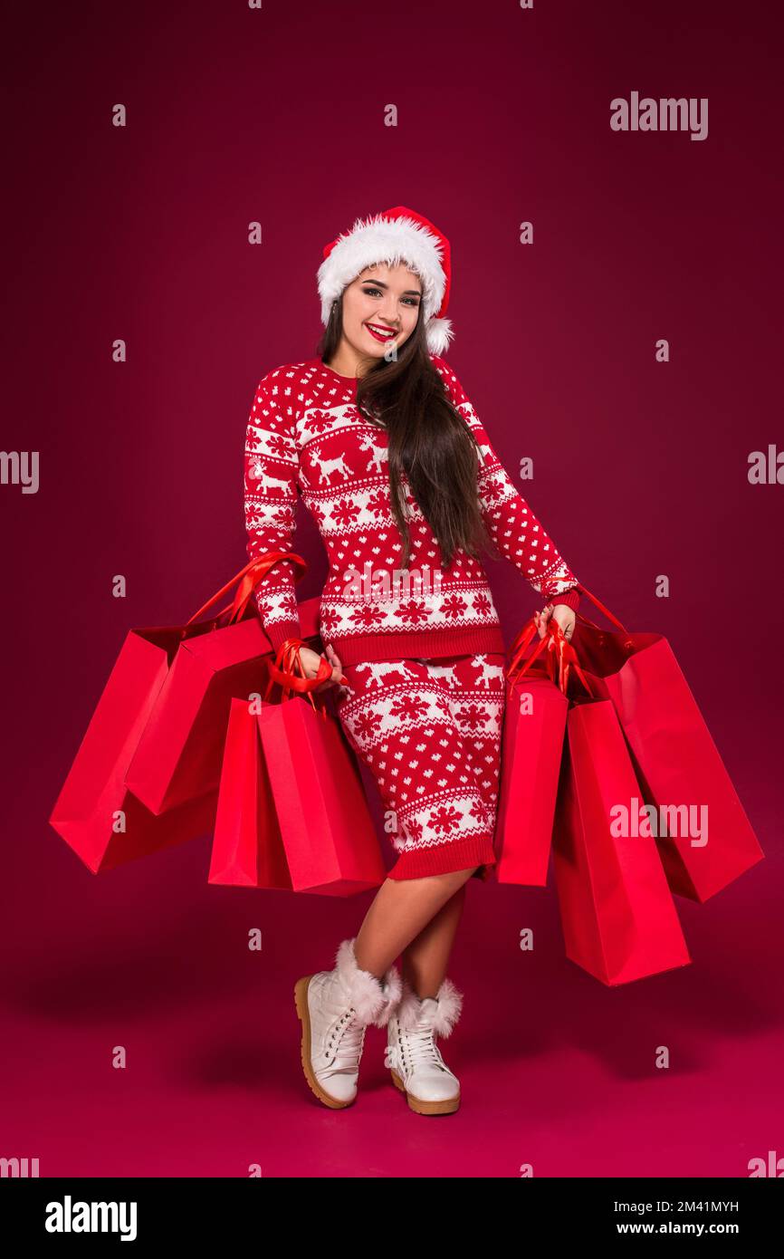 Attractive woman is holding many packages of bought presents with both ...