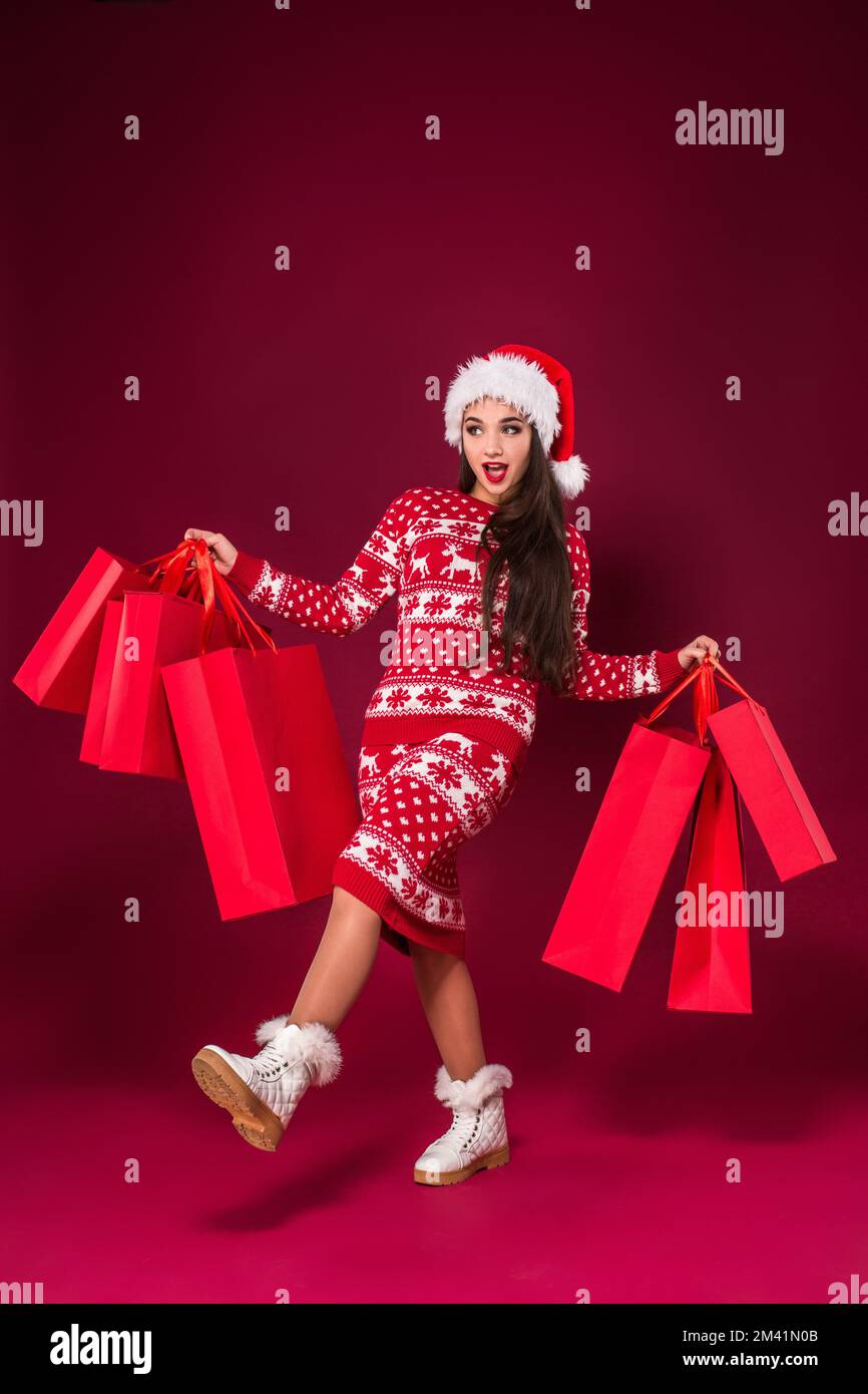 Attractive woman is holding many packages of bought presents with both ...