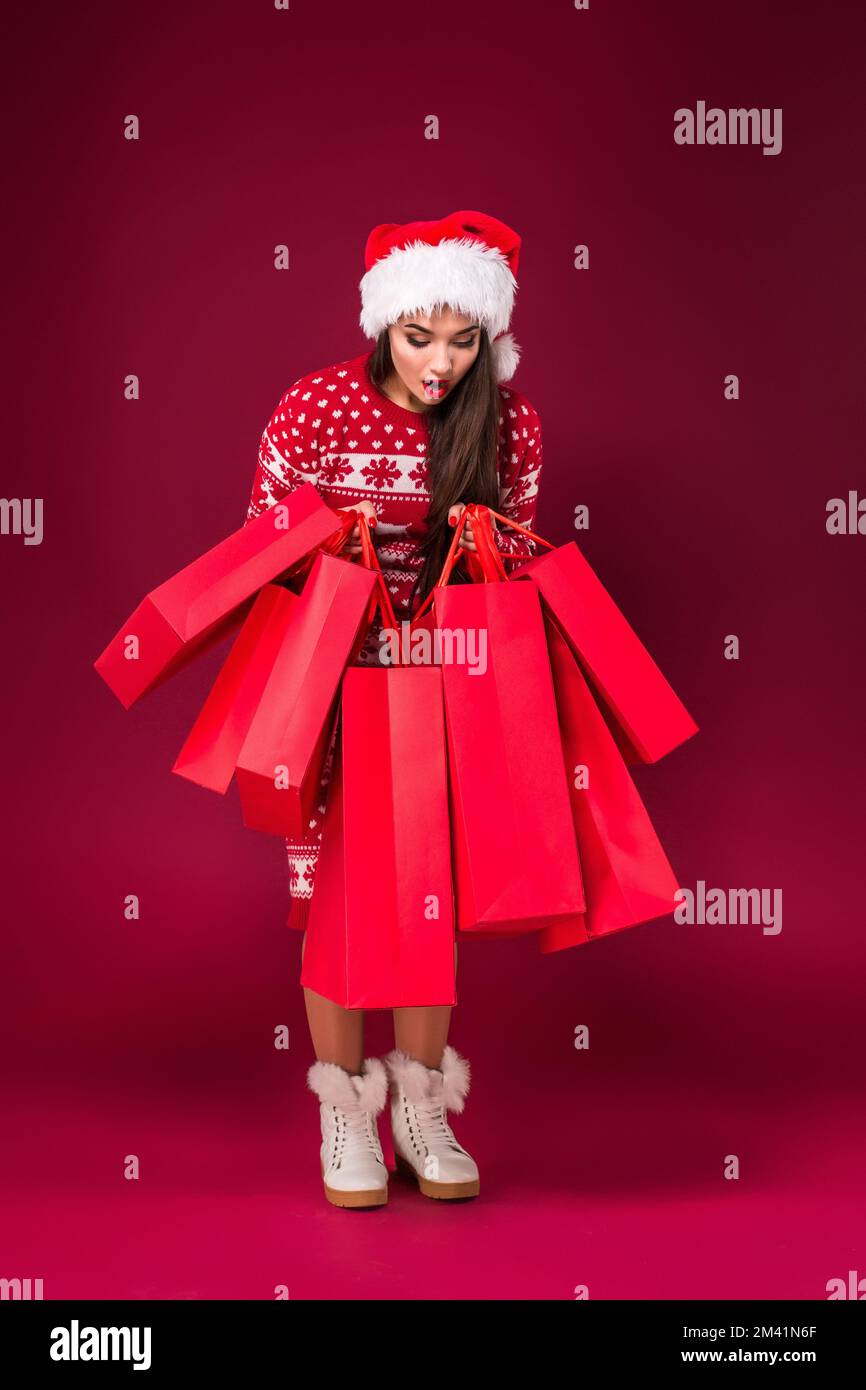 Attractive woman is holding many packages of bought presents with both ...