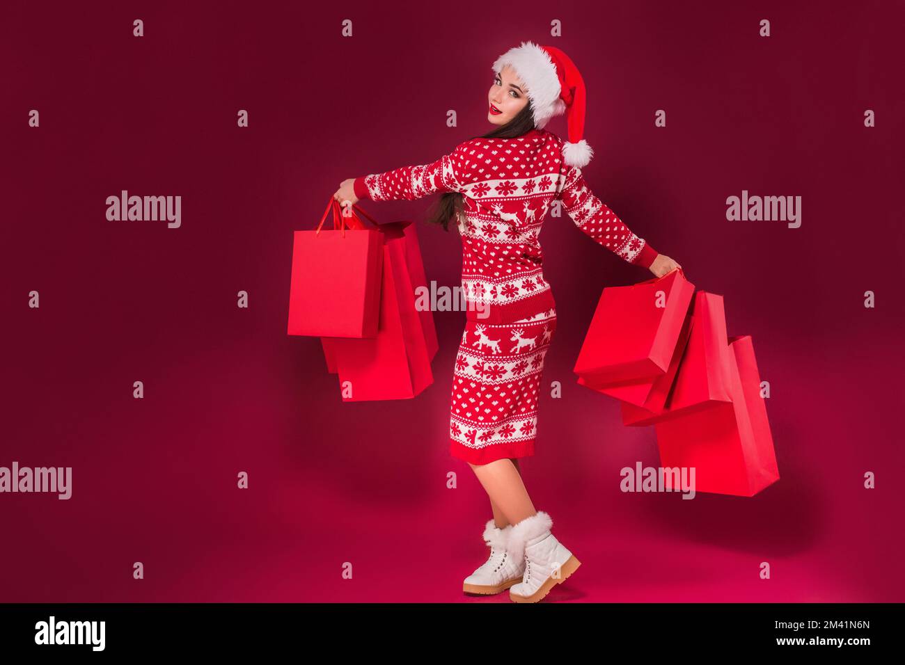 Attractive woman is holding many packages of bought presents with both ...