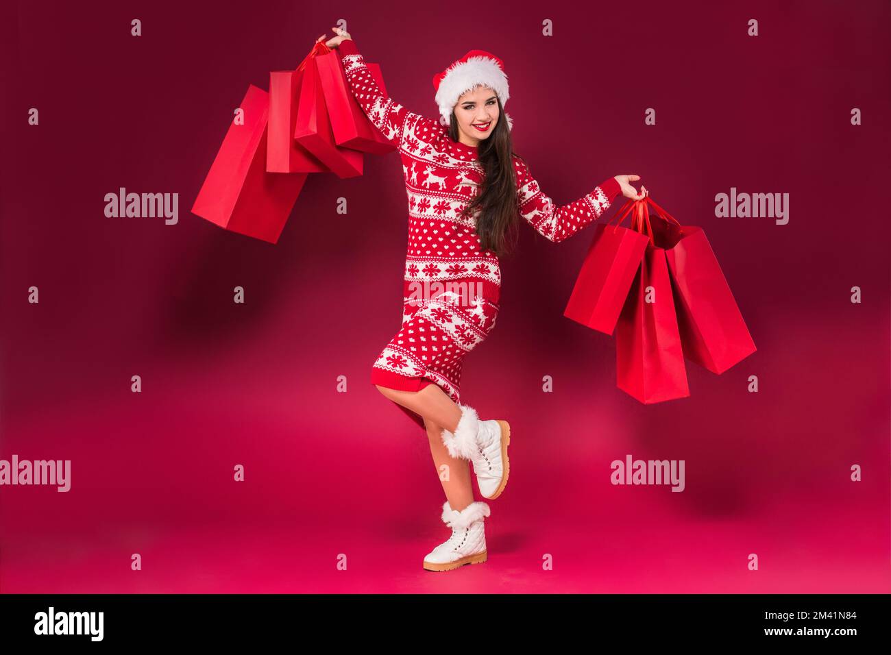 Attractive woman is holding many packages of bought presents with both ...