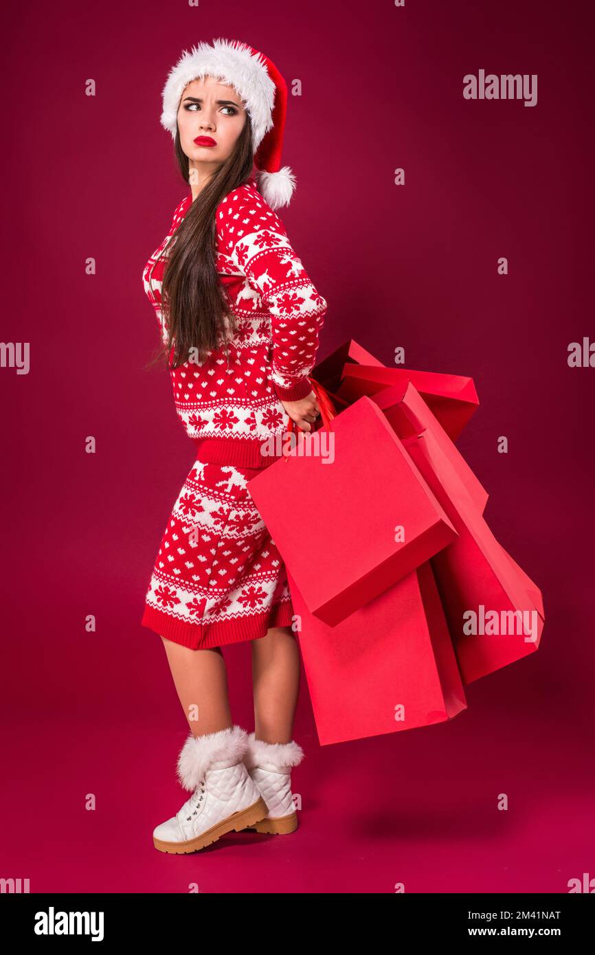Attractive woman is holding many packages of bought presents with both ...