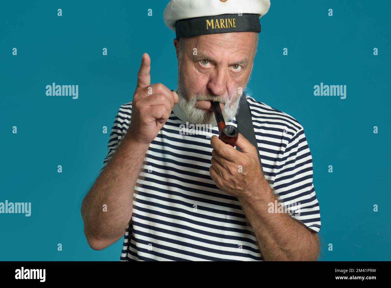 An old sailor smoking a pipe In a marine vest striped shirt and a ...