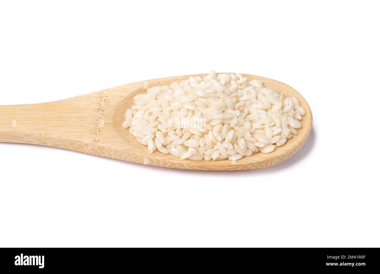 Raw carnaroli risotto rice on a spoon isolated over white background ...