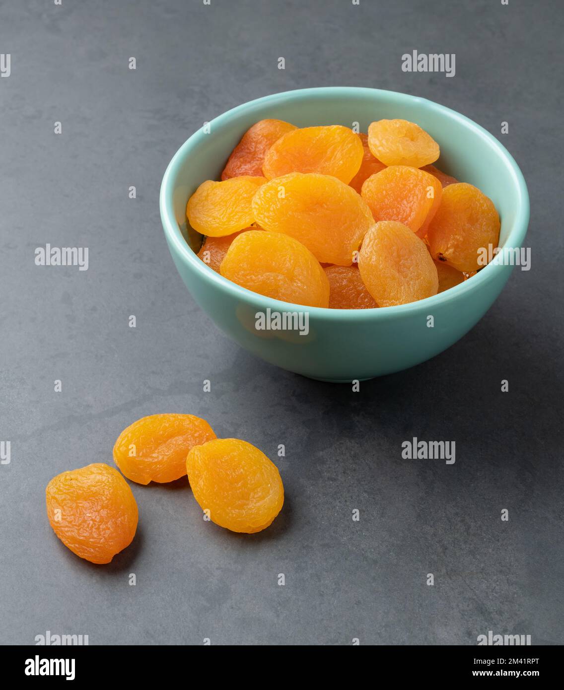 Dried apricots on a bowl over stone background Stock Photo - Alamy