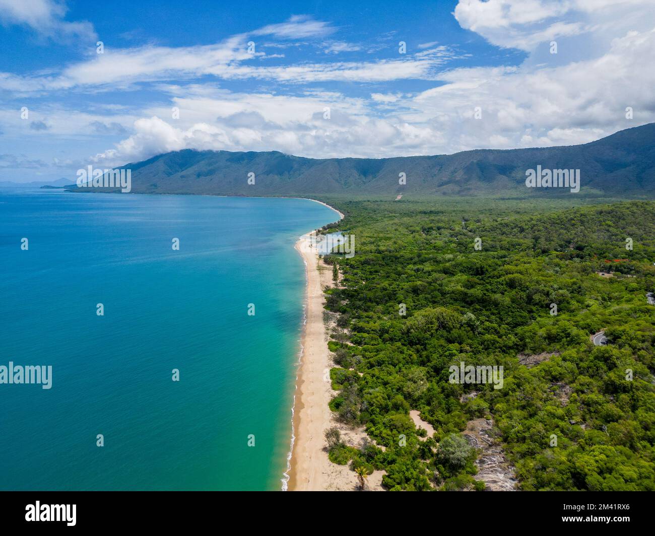 Aerial view of tropical beach, lush rainforrest, mountains and ocean ...
