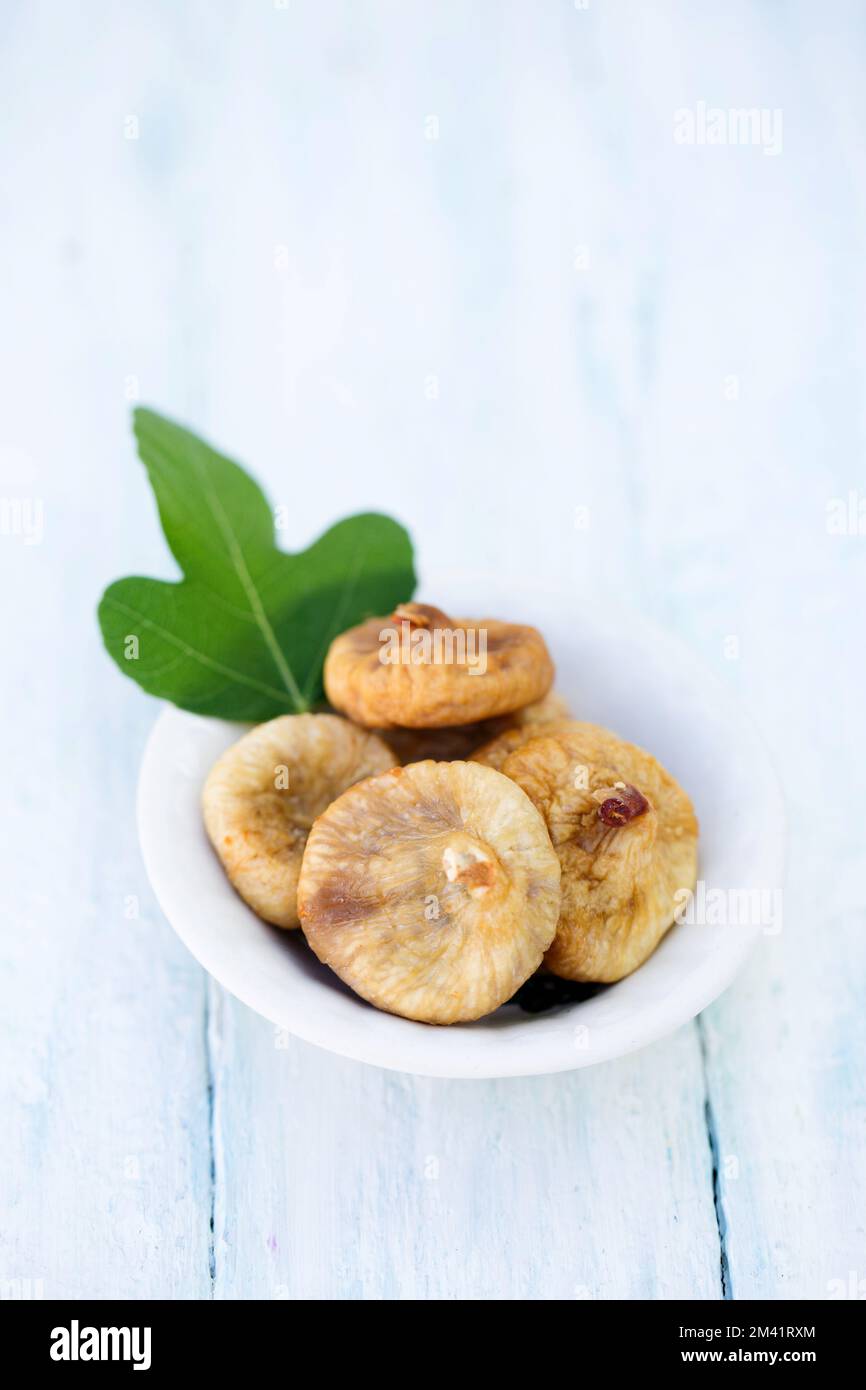 Delicious healthy dried figs with a fig tree leaf in a small bowl Stock ...