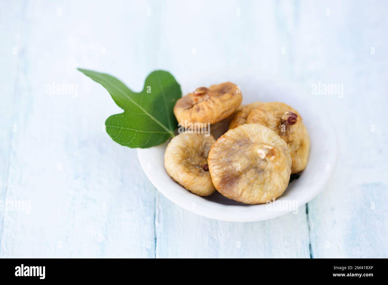 Delicious healthy dried figs with a fig tree leaf in a small bowl Stock ...