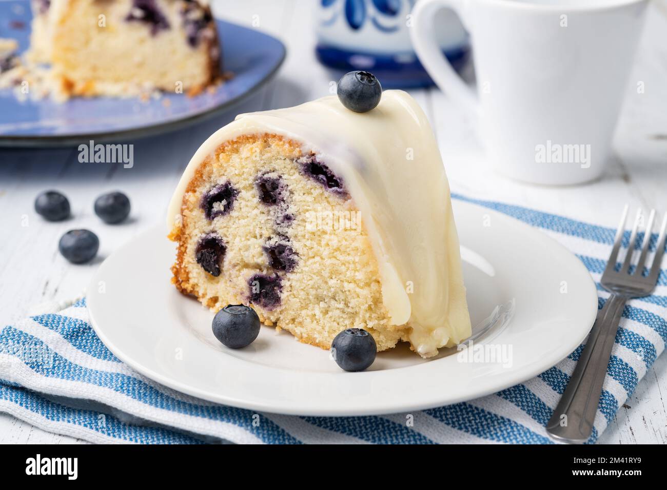 Lemon blueberry cake slice in a plate over wooden table Stock Photo - Alamy