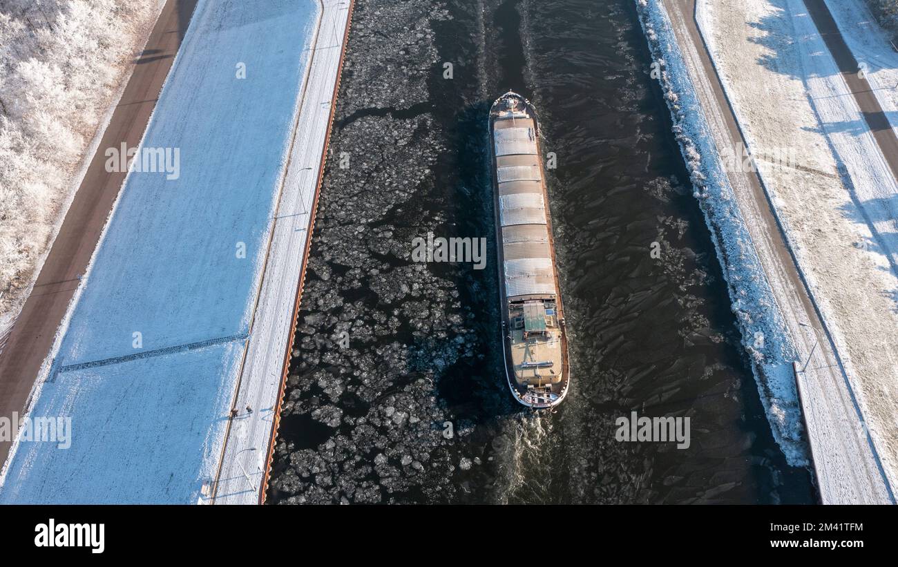 Magdeburg, Germany. 18th Dec, 2022. A barge crosses the icy Magdeburg ...
