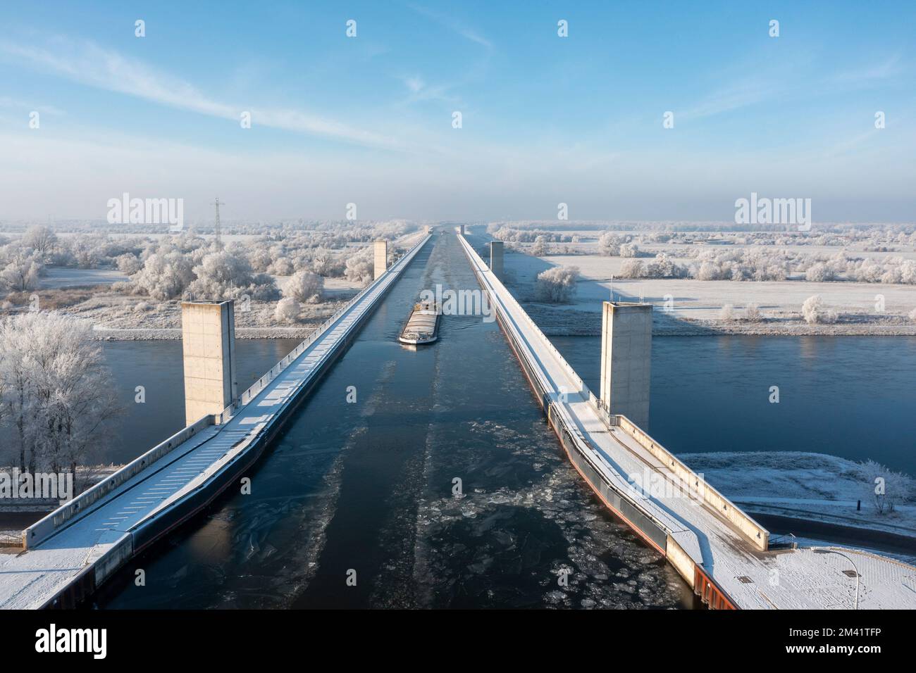 Magdeburg, Germany. 18th Dec, 2022. A barge crosses the icy Magdeburg ...
