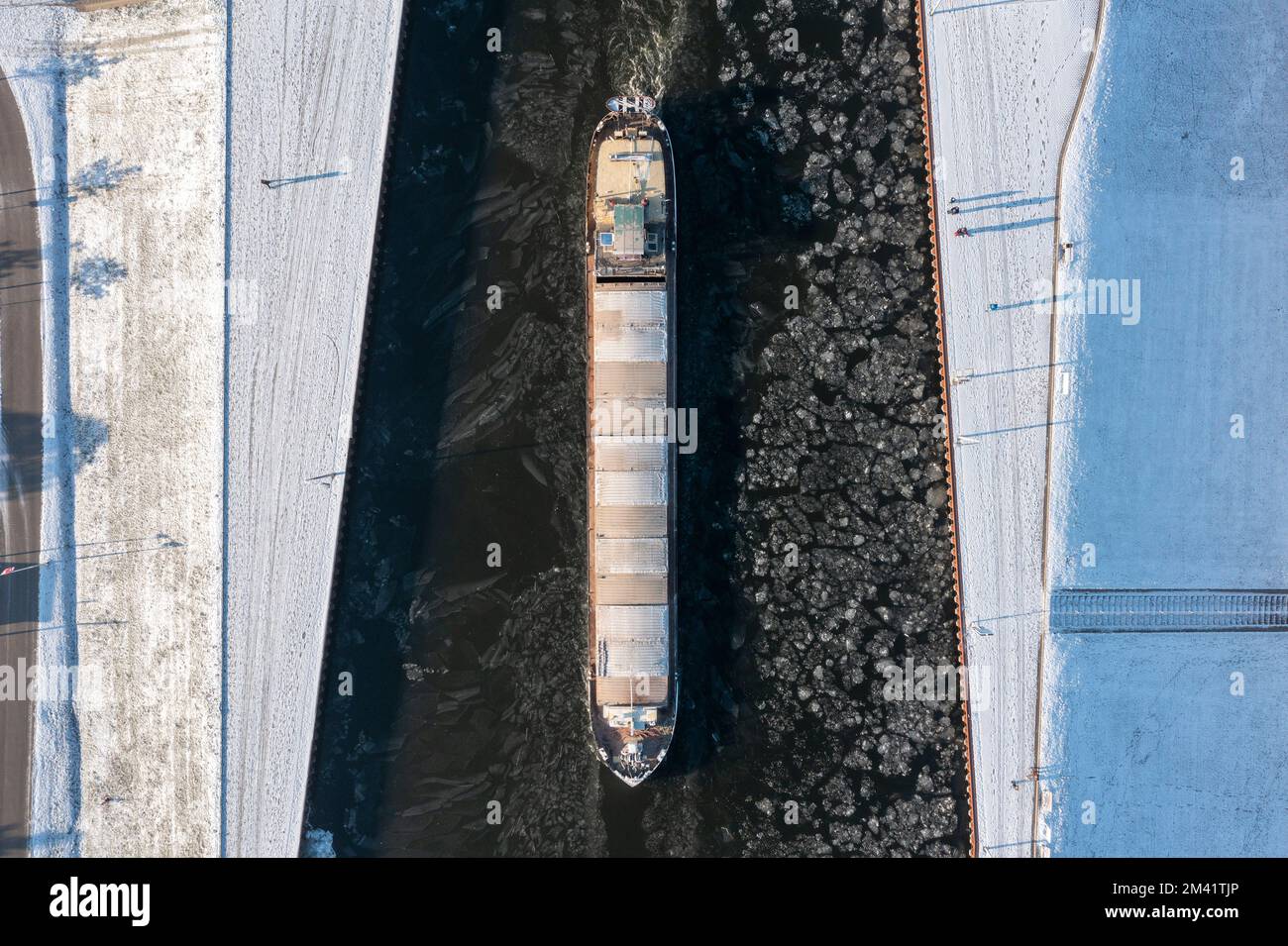 Magdeburg, Germany. 18th Dec, 2022. A barge crosses the icy Magdeburg ...
