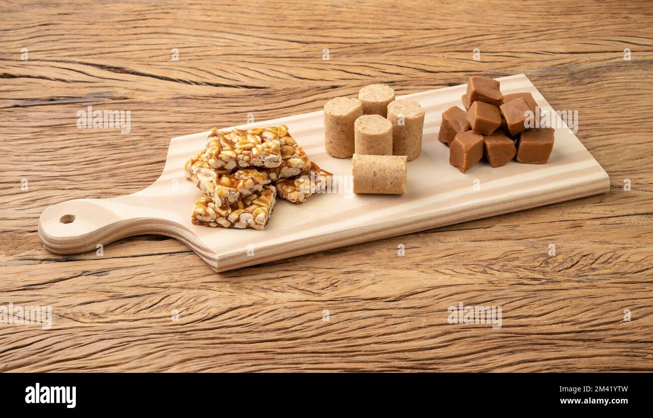 Typical brazilian candies over wooden board. Doce de leite or dulce de ...